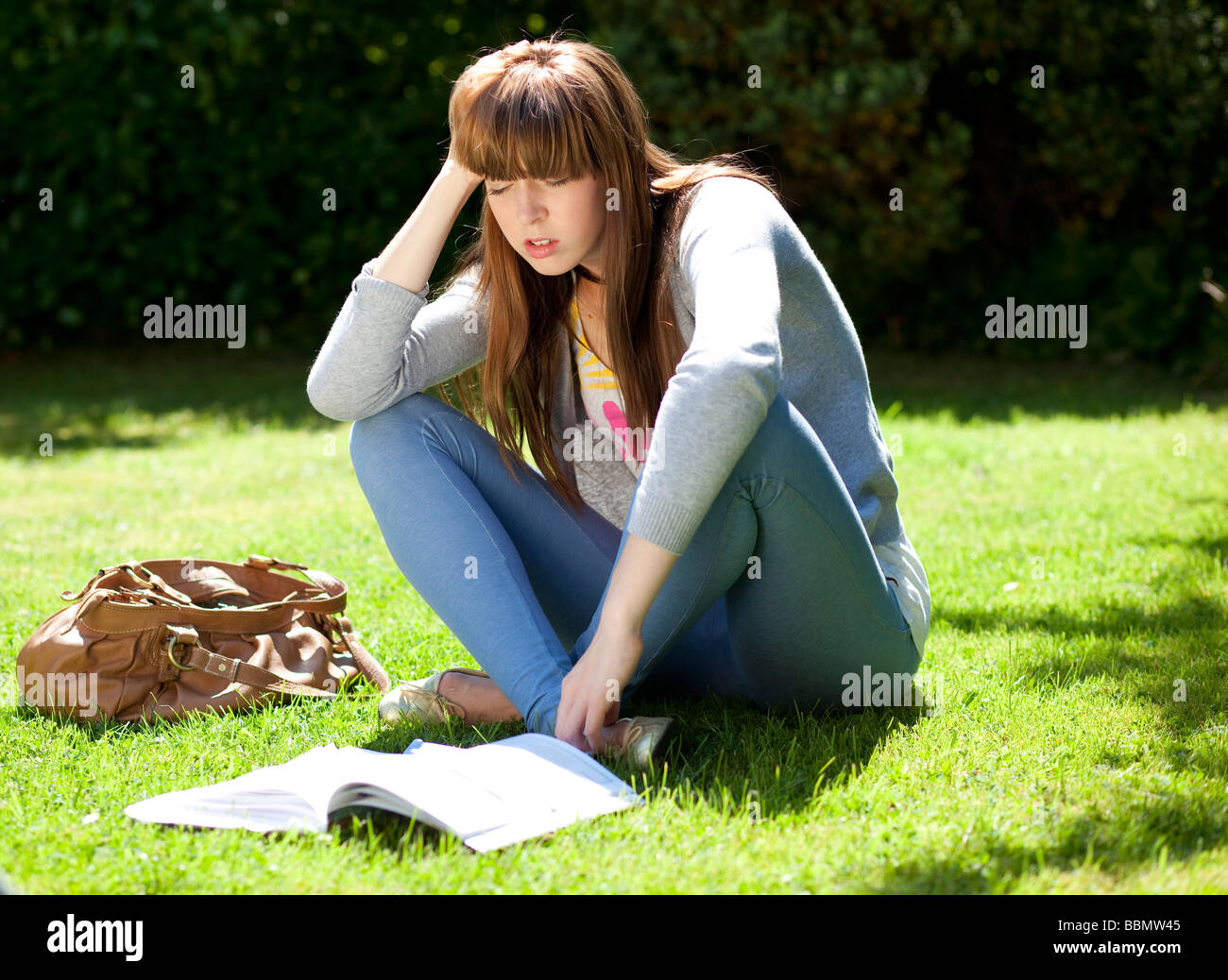 Girl with books outside on grass Stock Photo - Alamy