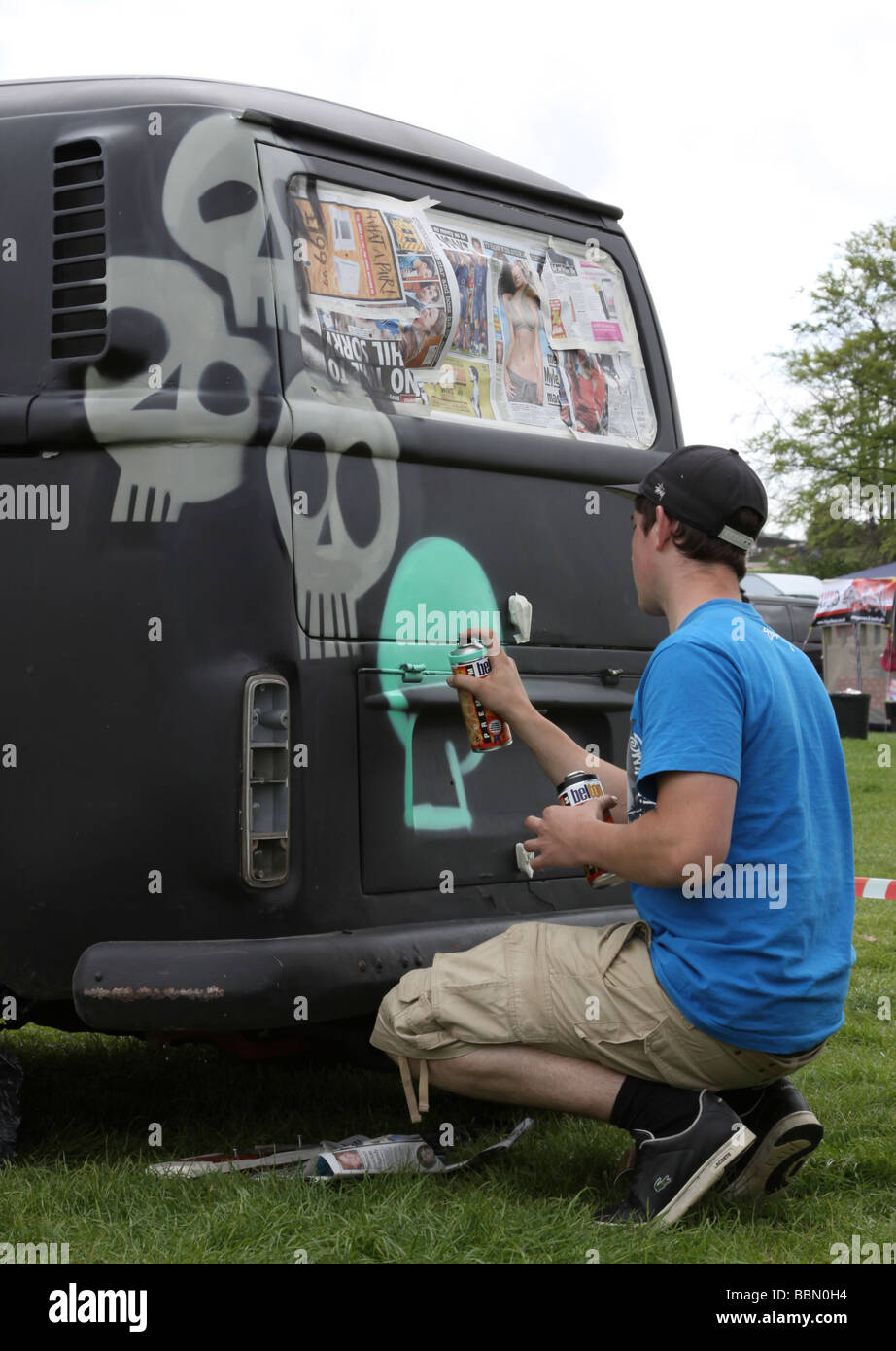 Black VW camper van being sprayed with graffiti Stock Photo - Alamy