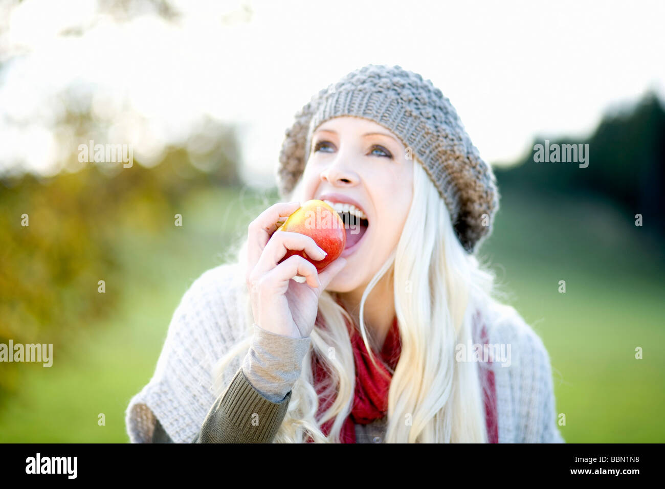 Young woman biting into an apple, portrait Stock Photo - Alamy