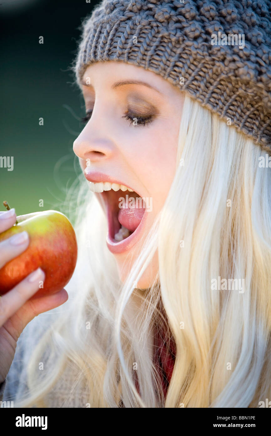 Young woman biting into an apple, portrait Stock Photo - Alamy