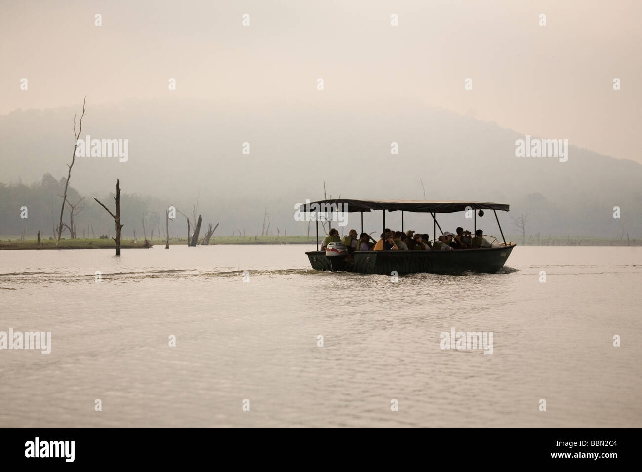 A group of tourists enjoy a boat safari on the Kabini backwaters of ...