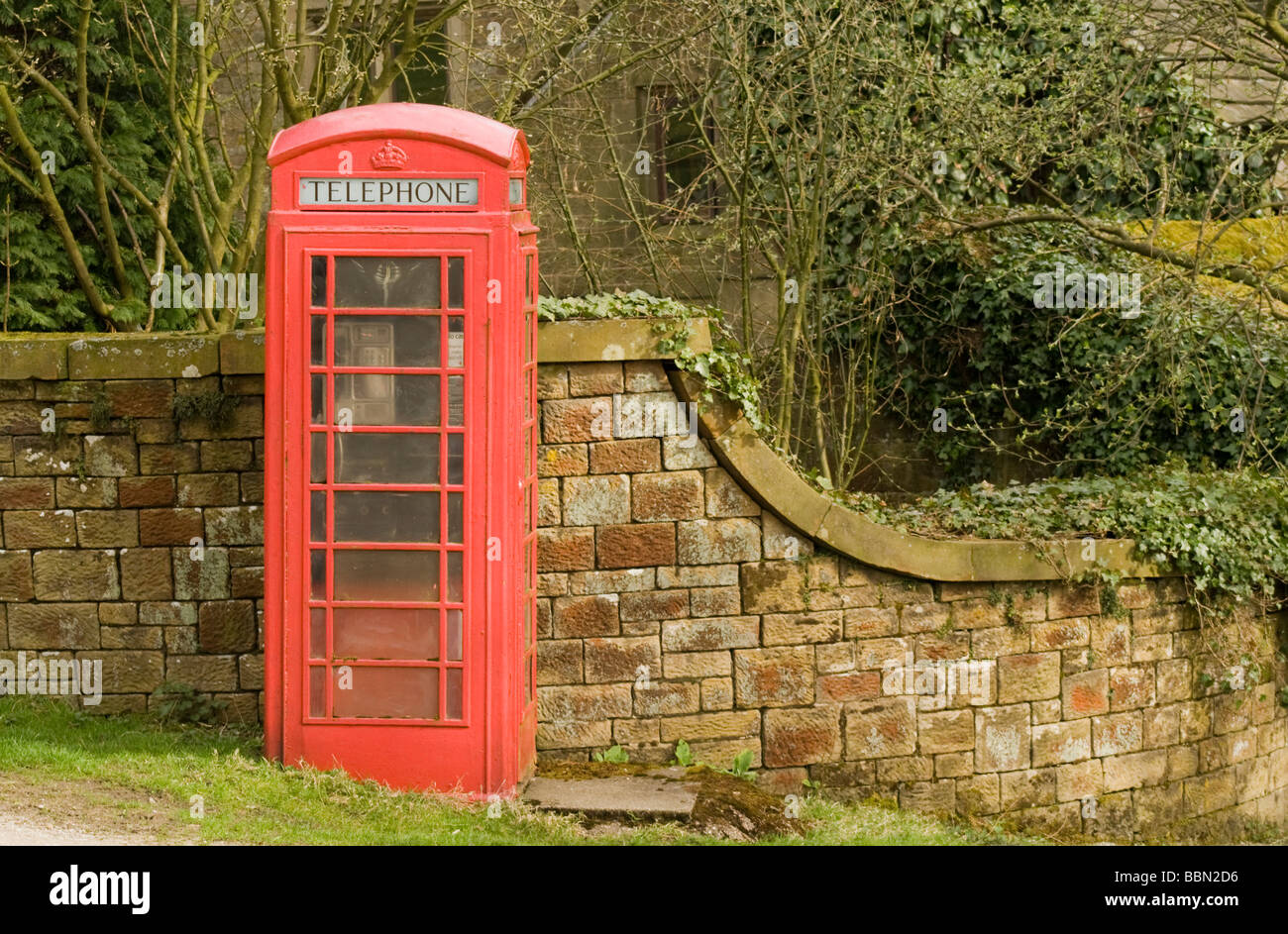 An old red telephone box against a brick wall Stock Photo - Alamy