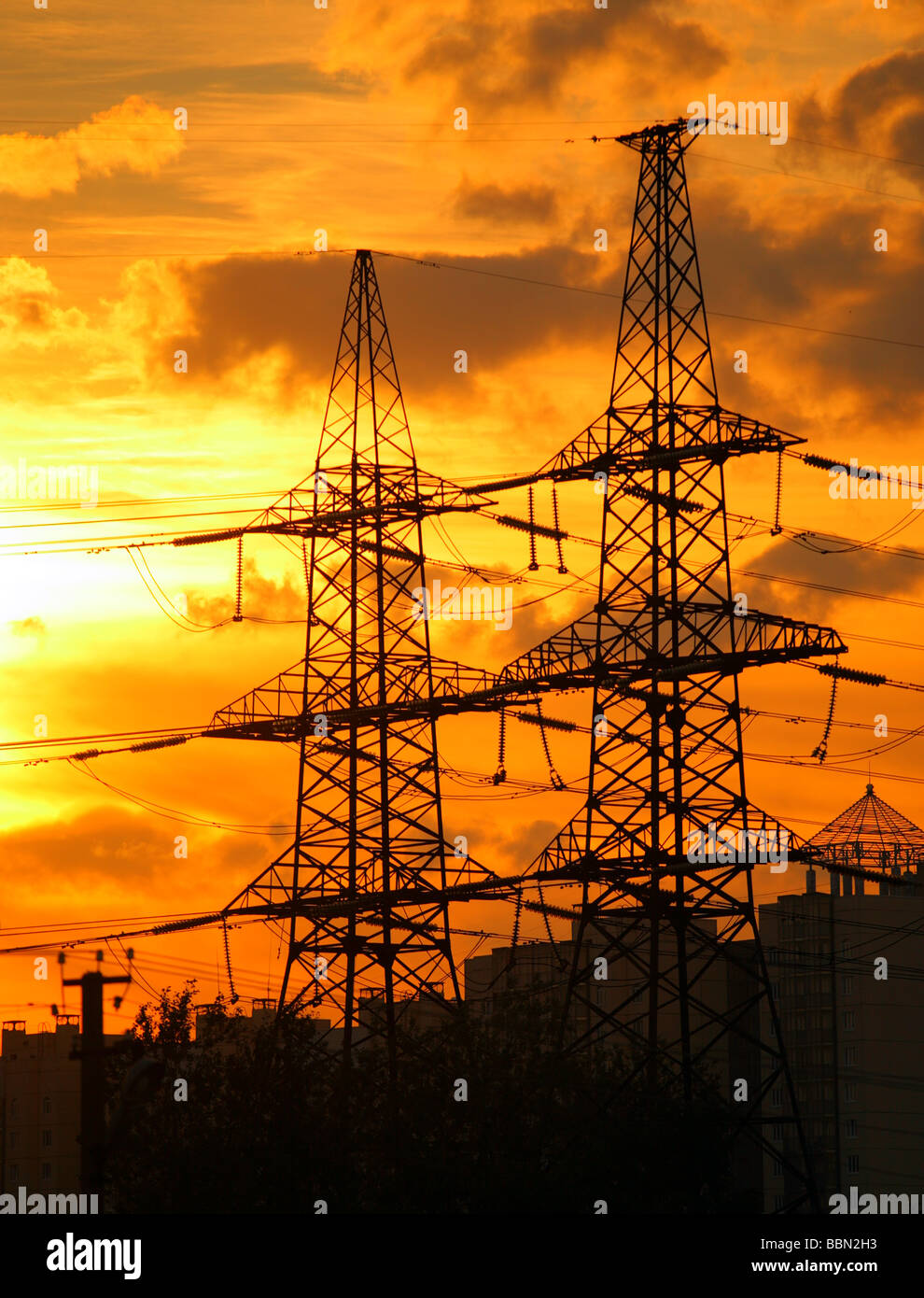 An electricity pylon with the sun setting behind Stock Photo - Alamy
