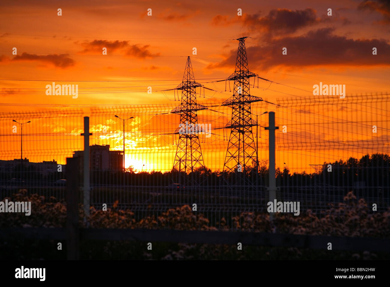 An electricity pylon with the sun setting behind Stock Photo - Alamy