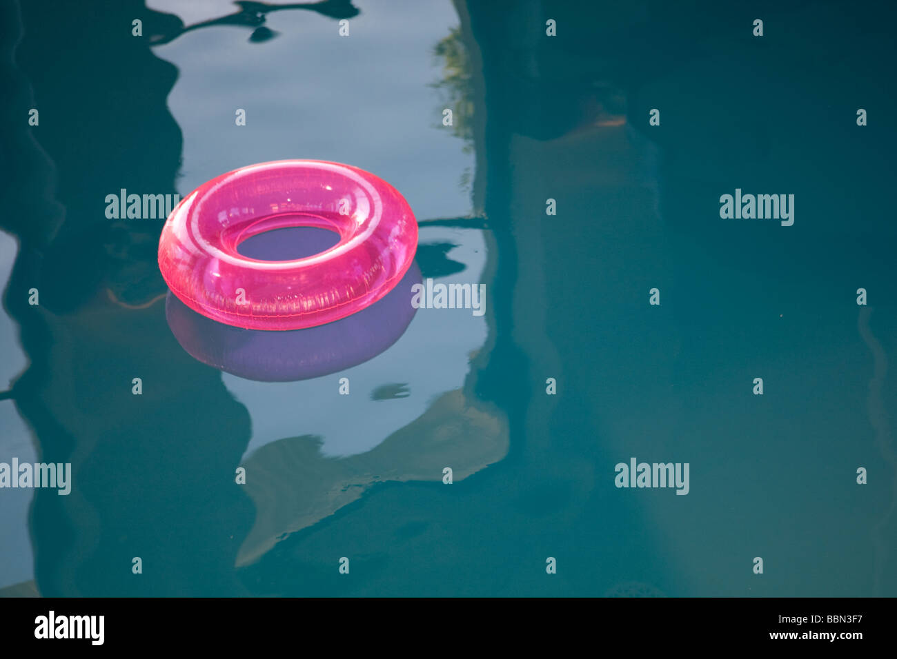 Pink inflatable ring floating in a pool Stock Photo - Alamy
