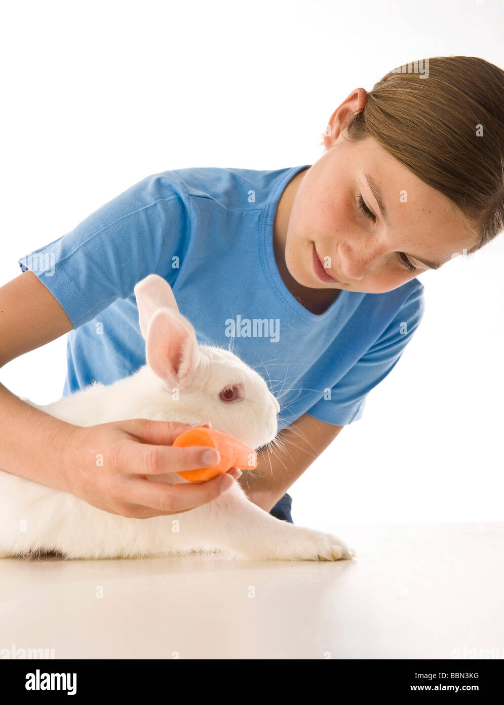 A girl feeding her white bunny with a carrot Stock Photo - Alamy