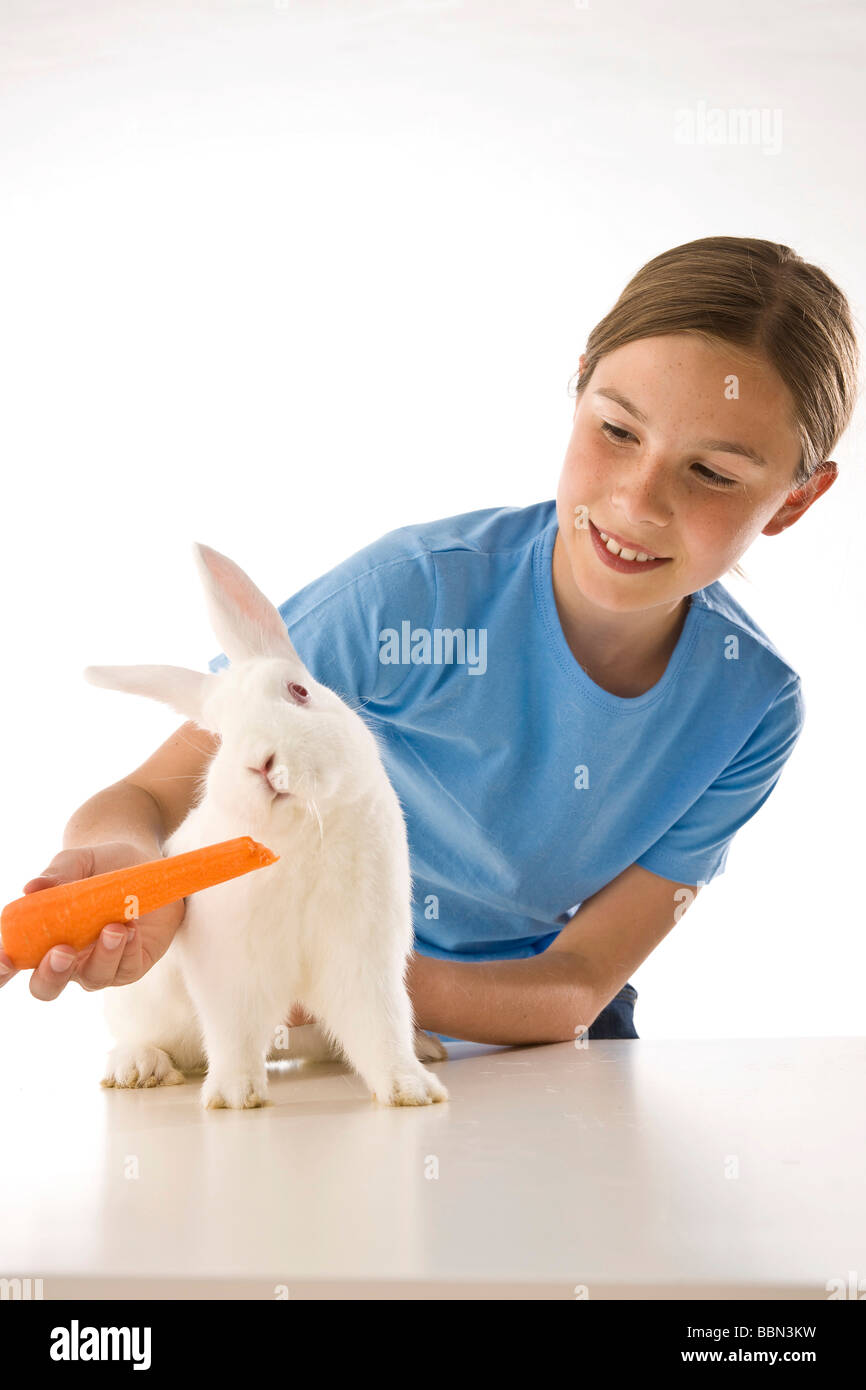 A girl feeding her white bunny with a carrot Stock Photo - Alamy