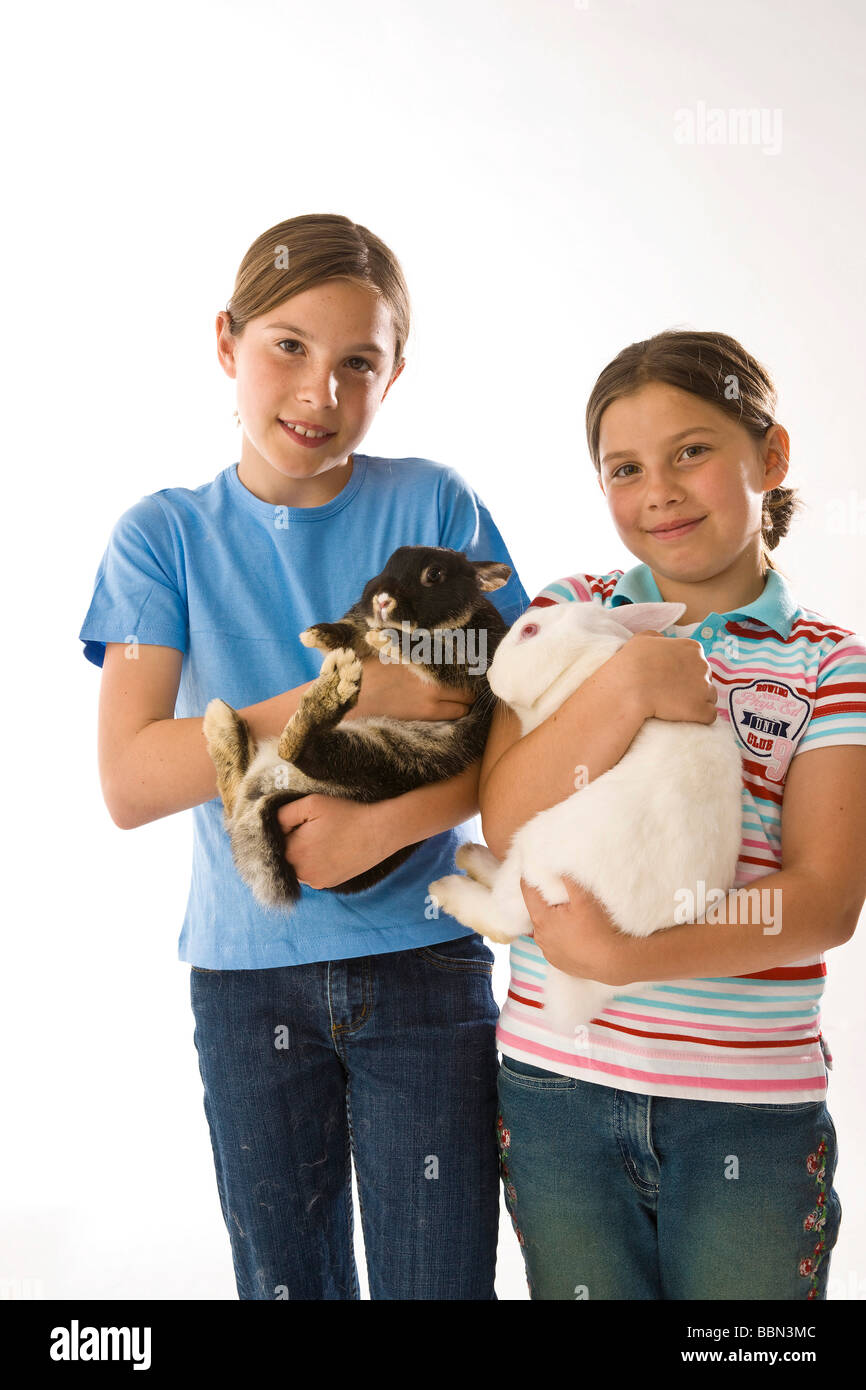 Two girls, each with a rabbit in her arms Stock Photo - Alamy