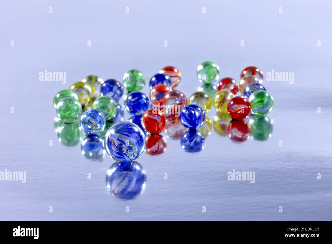 Many colourful marbles on a reflective surface for a background use ...