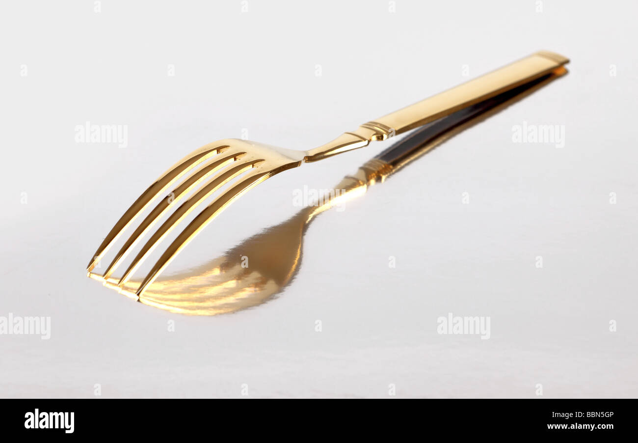 Single golden fork on a reflective background for a simple abstract ...