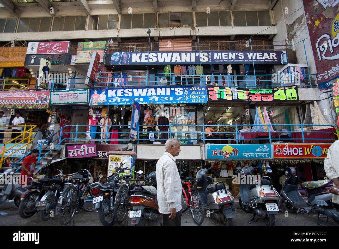 Indian man walking by brightly decorated three story strip mall Stock ...