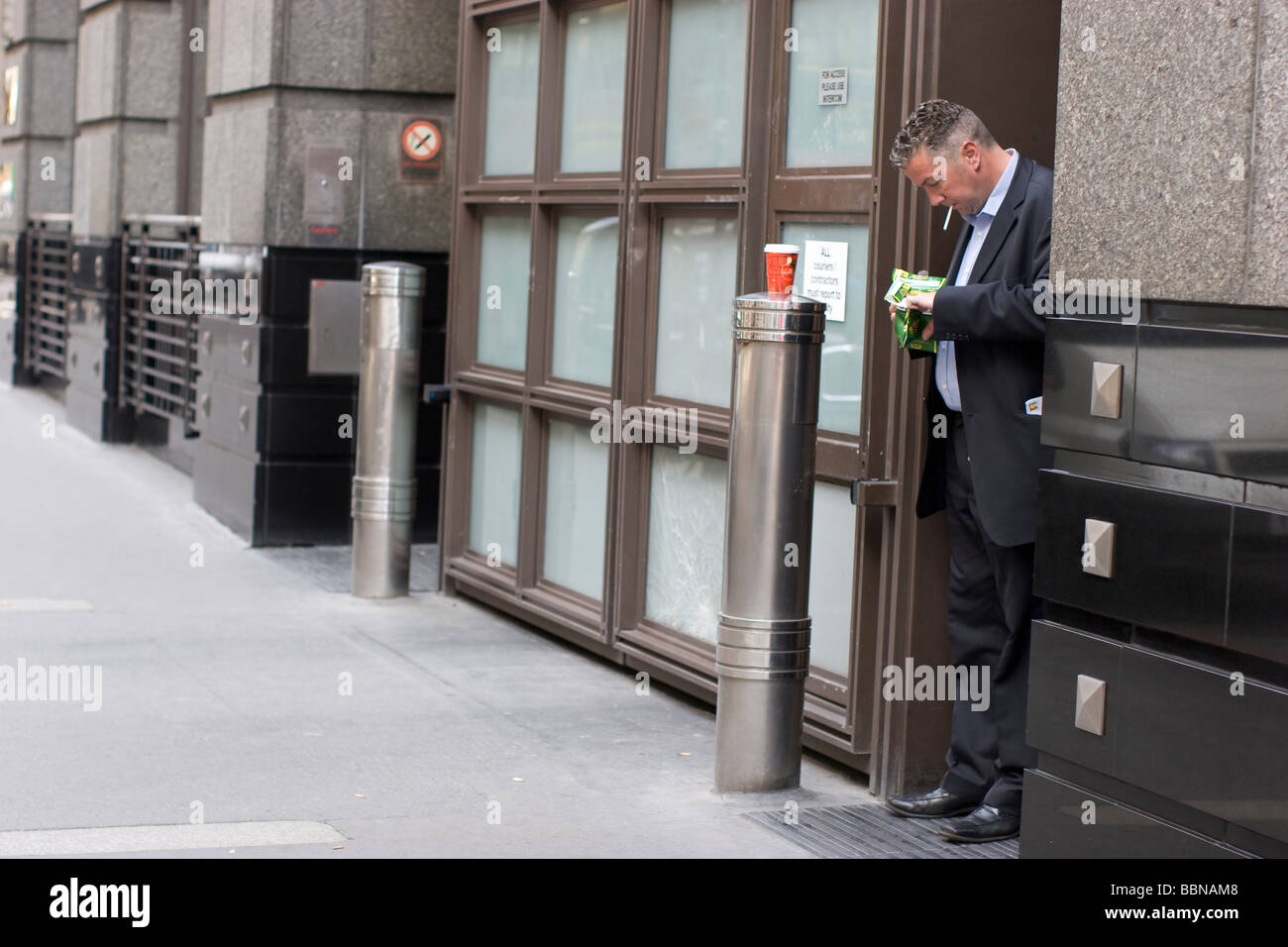 roll up, city worker Smoker in doorway London UK smoker rolling up ...