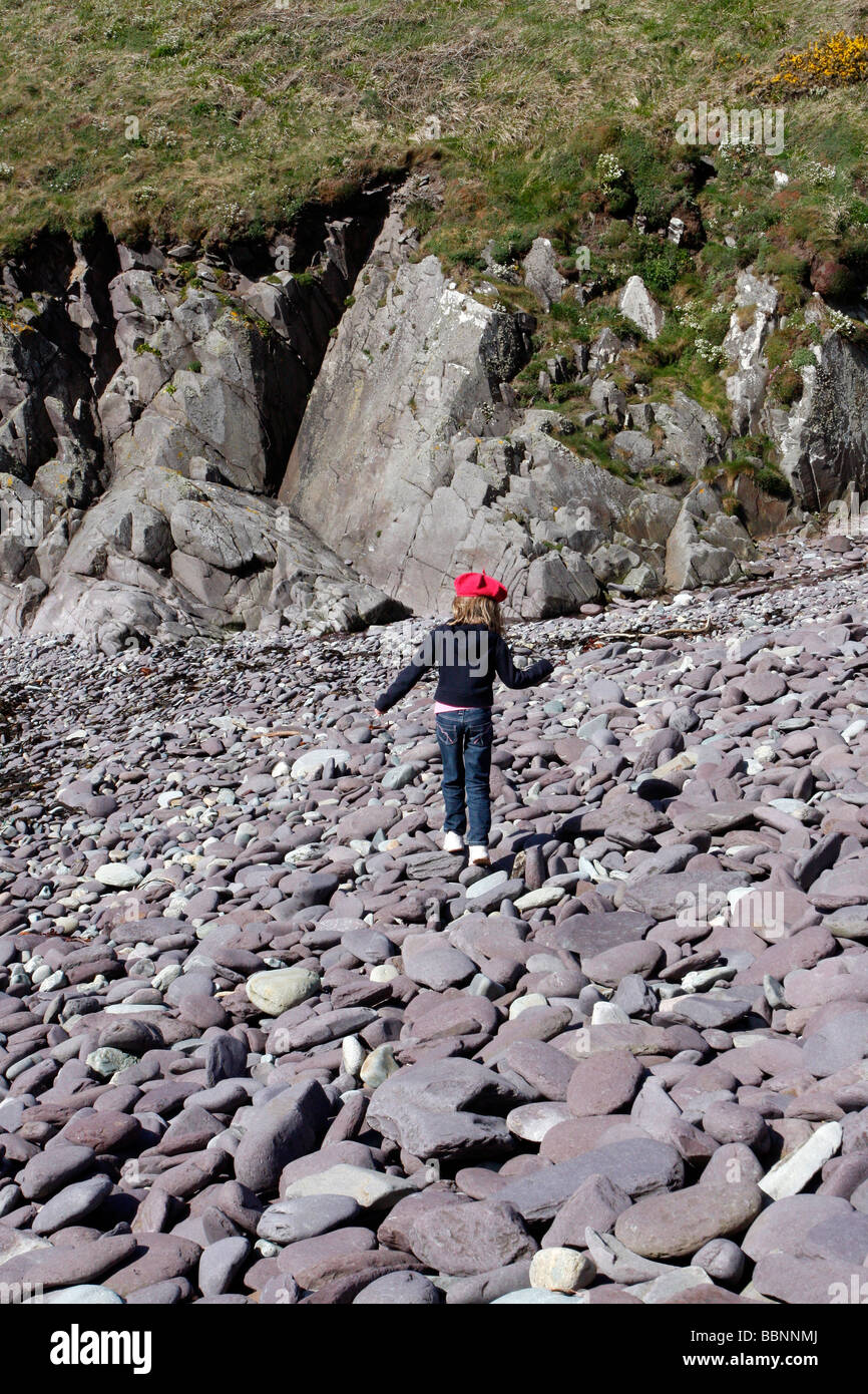 Young girl walking over rocks stones Caer Bwdy bay Pembrokeshire ...