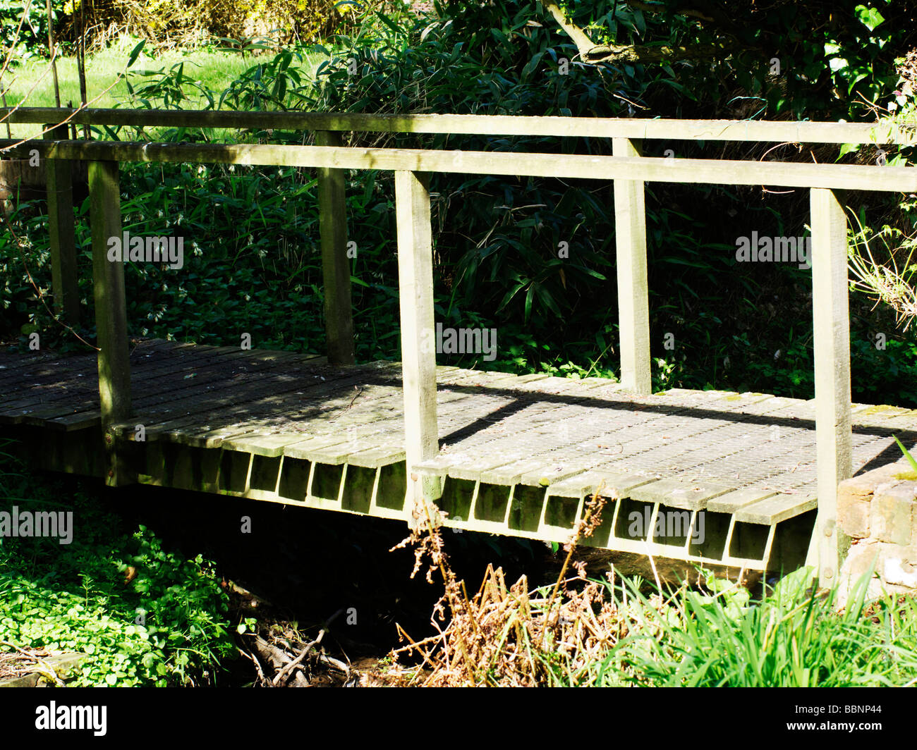 garden bridge over stream green vegatation footbridge Stock Photo - Alamy