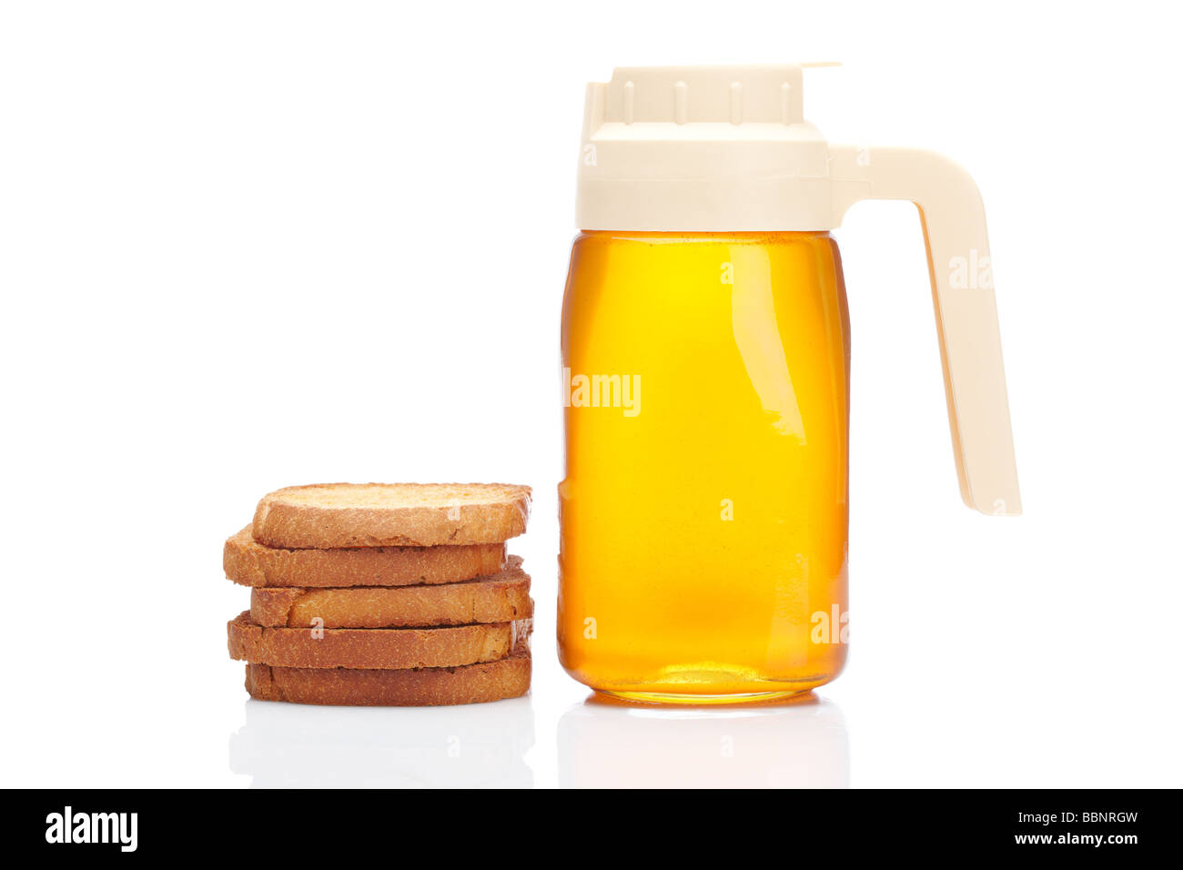Honey pitcher and pile of toasts reflected on white background Stock ...