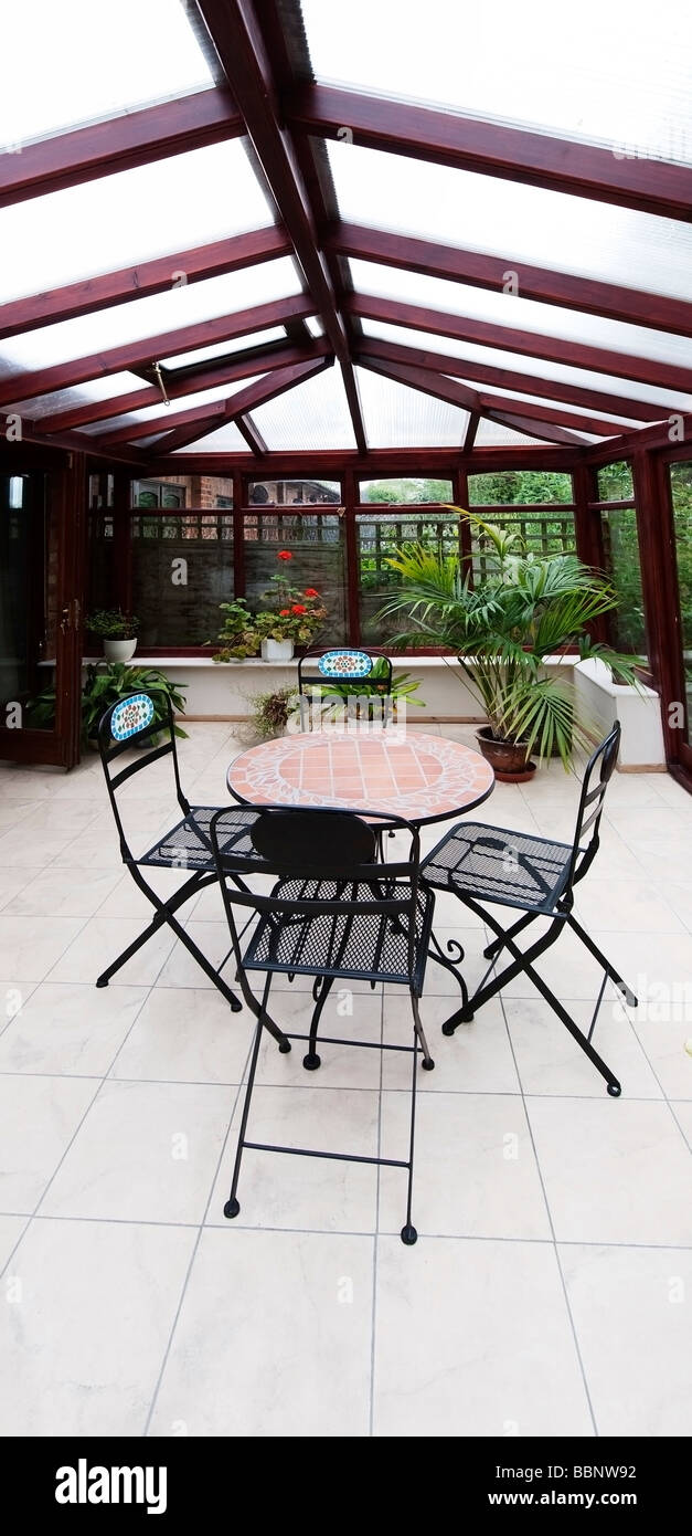 conservatory tables chairs plants room in house next to garden Stock ...