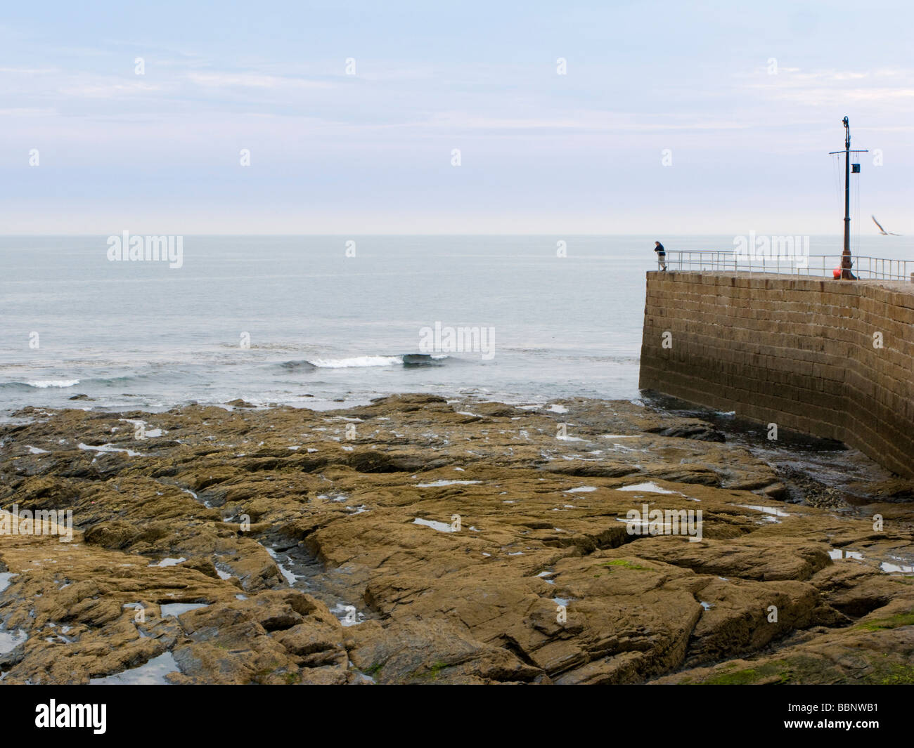 Lone man on pier Porthleven Cornwall UK Stock Photo - Alamy