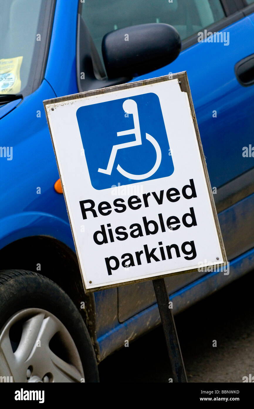 Reserved Disabled Parking sign next to blue car in car park Stock Photo ...