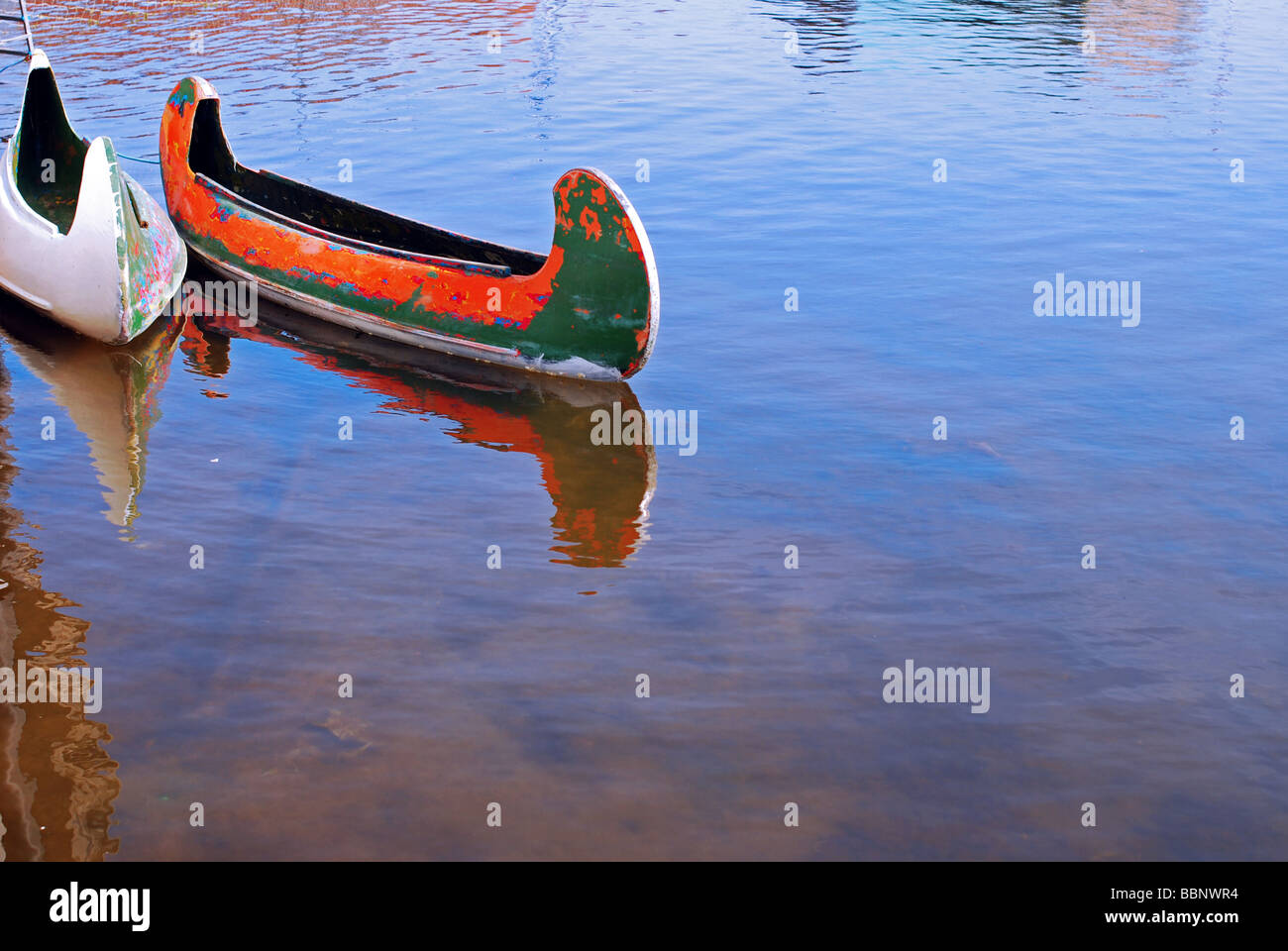 Canoes on a shallow lake, with reflections Stock Photo - Alamy
