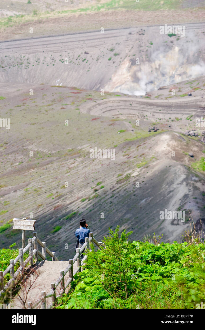 A man looks out at the smouldering crater of the still active volcano ...