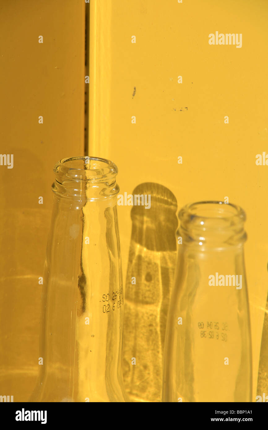 empty glass drinks bottles by yellow wall Stock Photo - Alamy