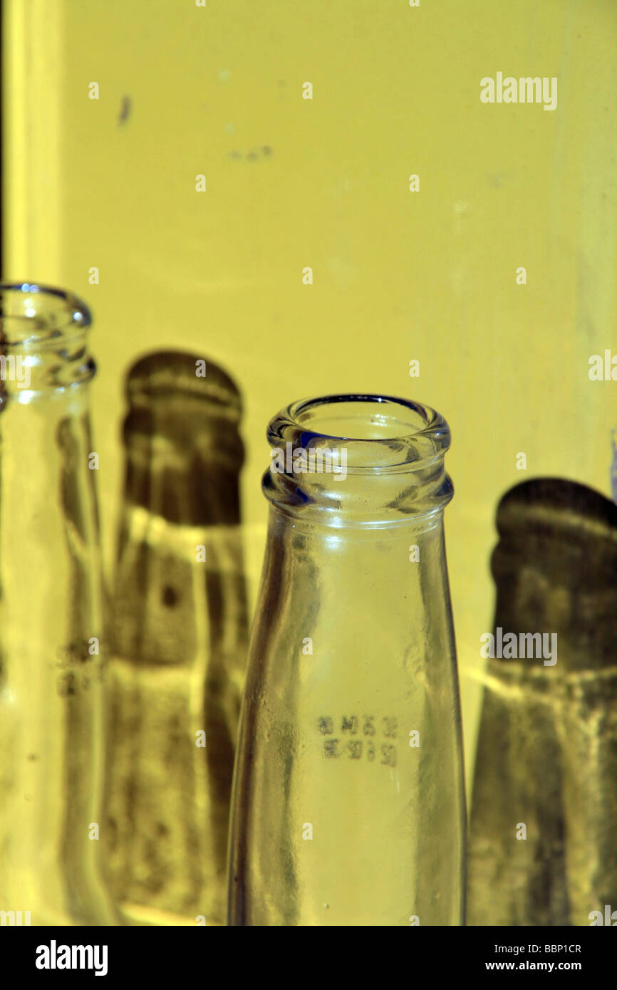 empty glass drinks bottles by yellow wall Stock Photo - Alamy