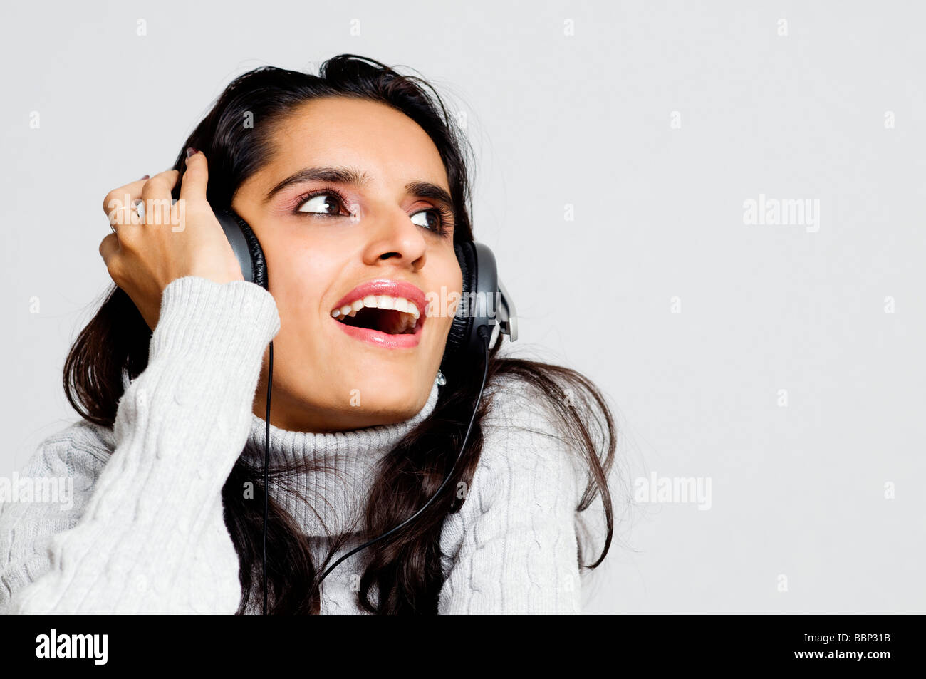 Asian Indian woman listening to music through headphones Stock Photo ...