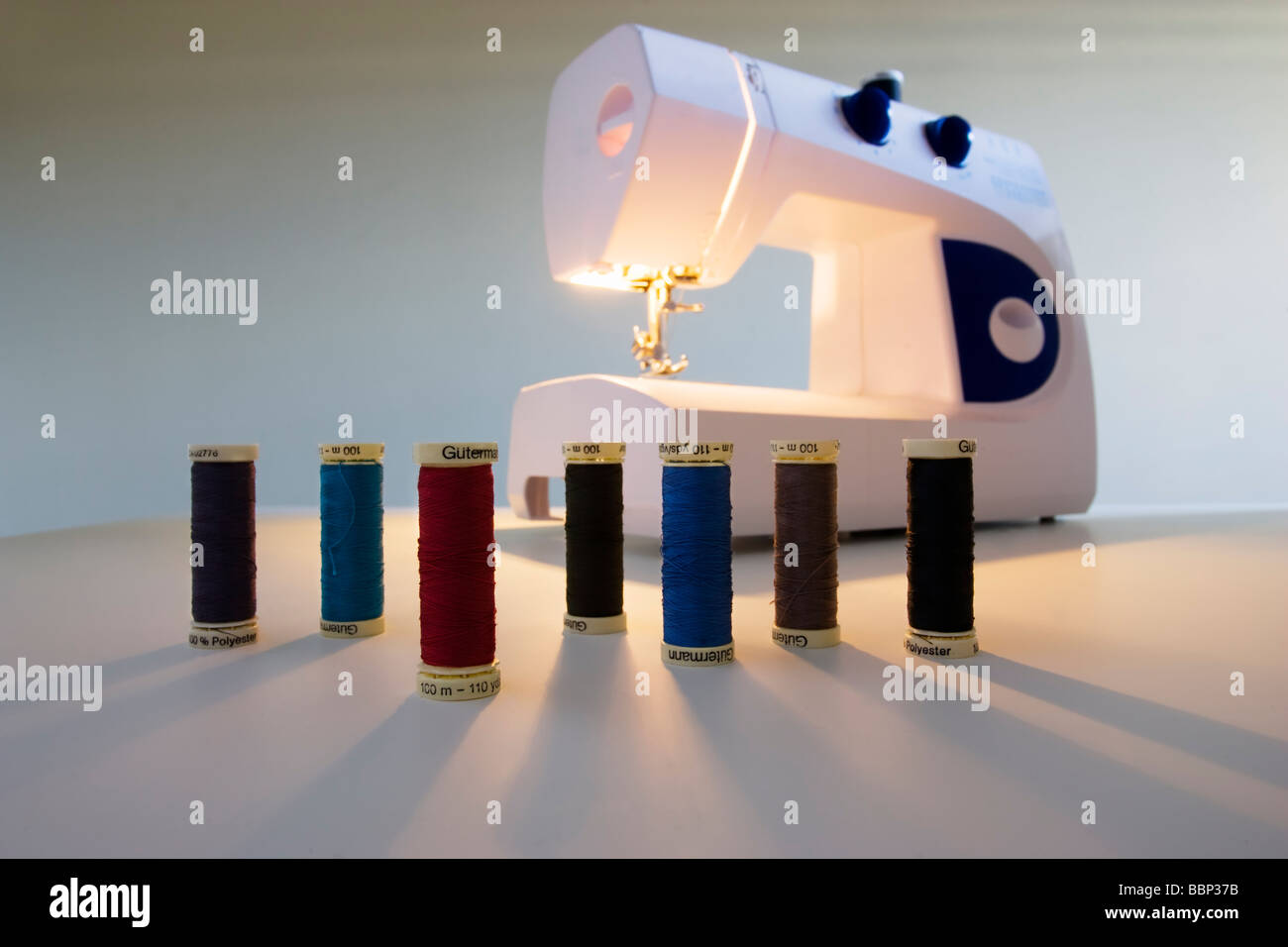 Cotton reels and a sewing machine Stock Photo - Alamy