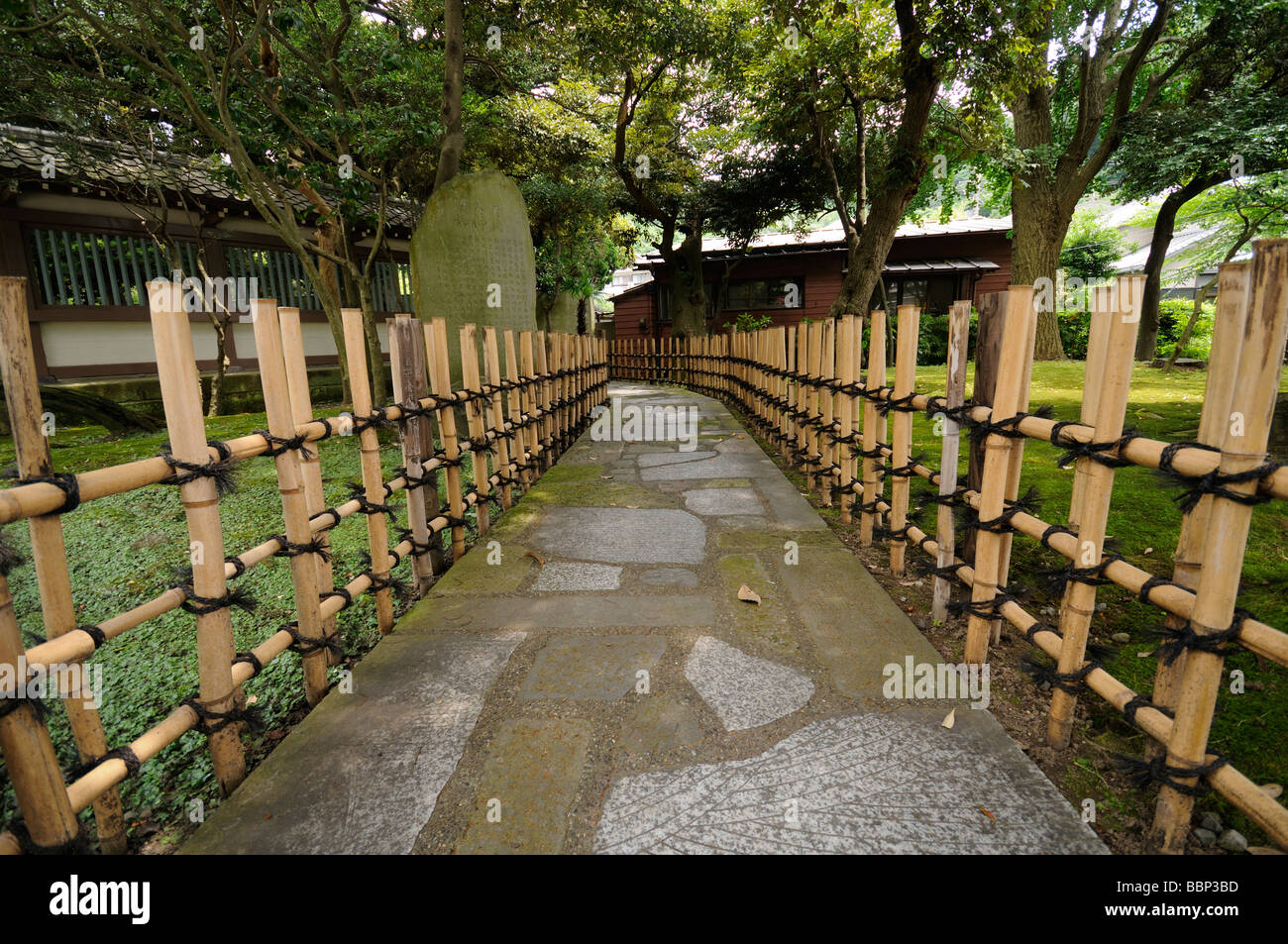 Pathway with bamboo fence at the entrance to Kotoku-in Temple. Kamakura ...
