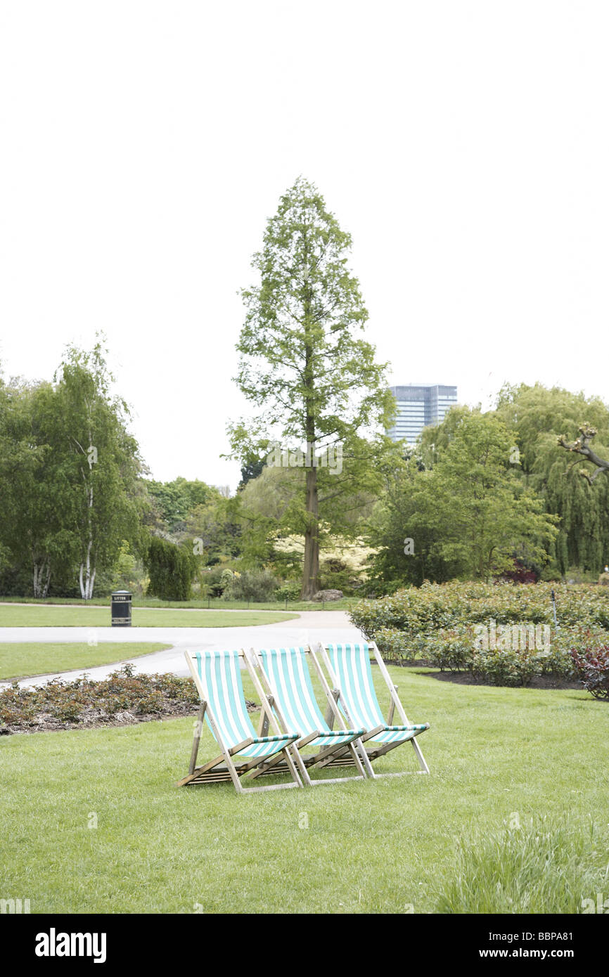 three empty deckchairs in a park Stock Photo - Alamy