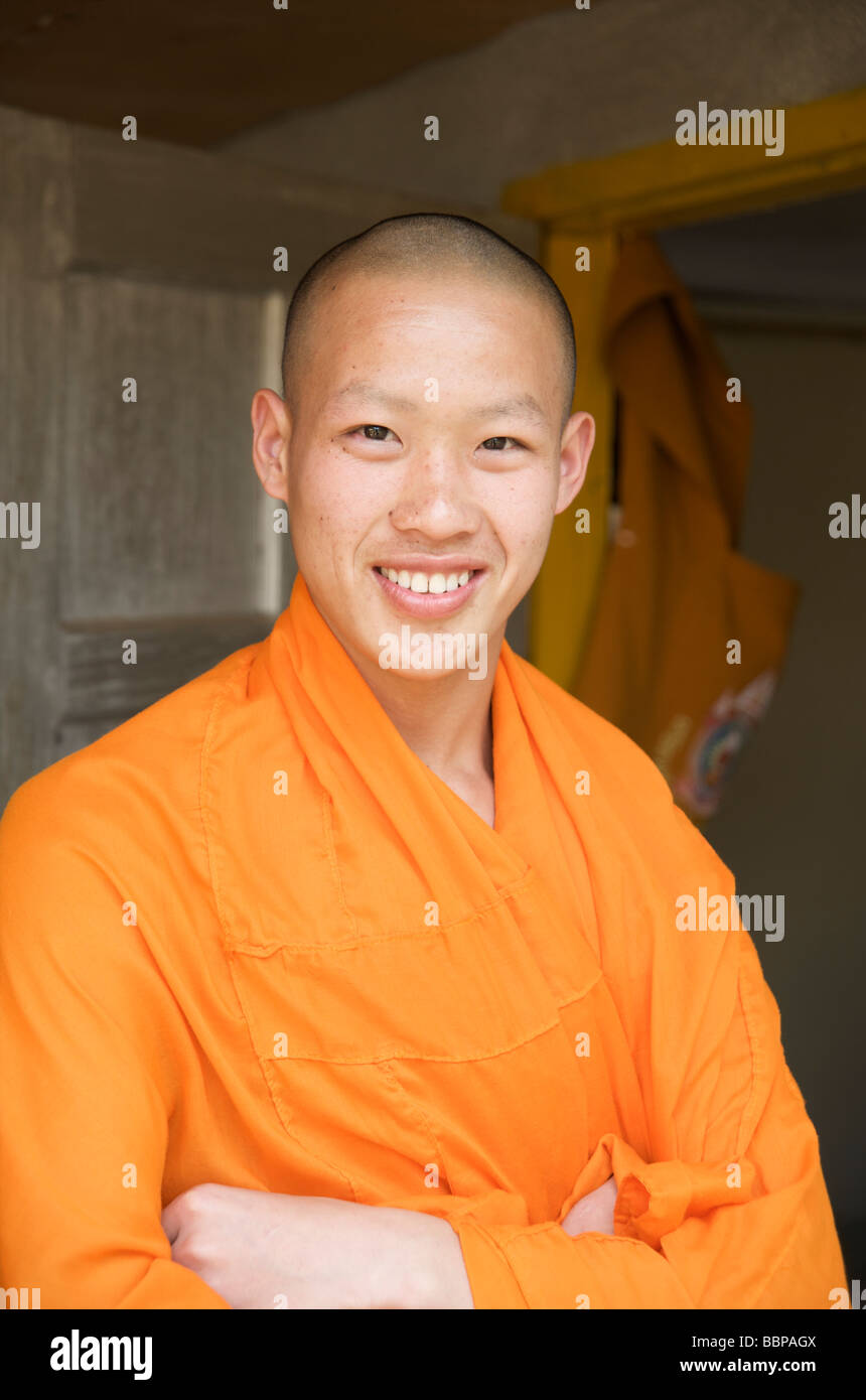 A young Buddhist monk smiles for the camera in his Luang Prabang temple ...
