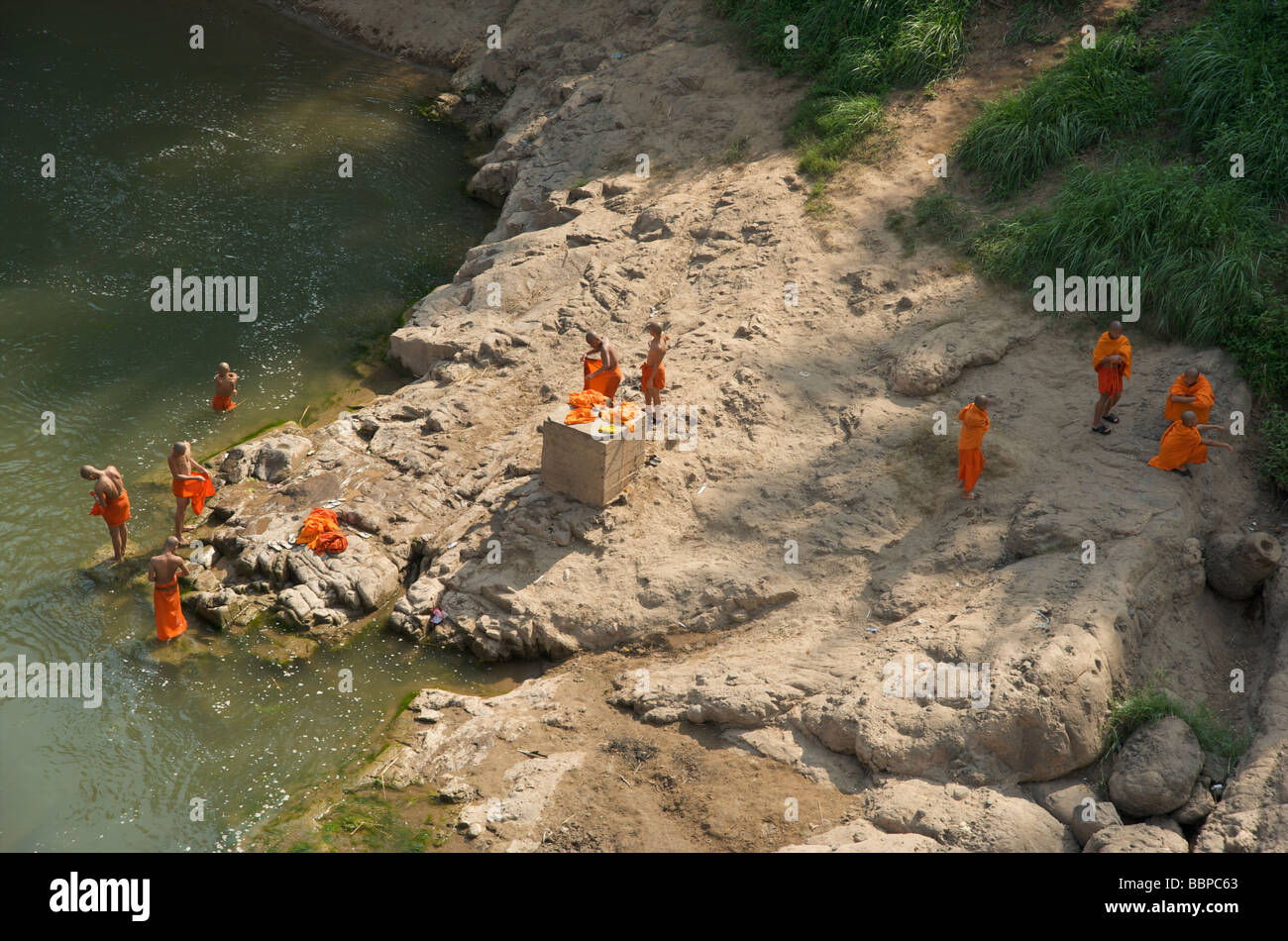 A group of Buddhist monks washing and swimming in the Nam Khan river in ...