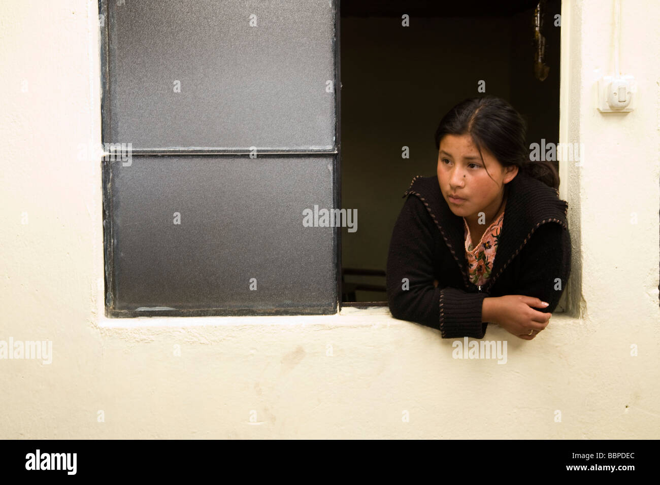 Guatemala;Young girl leaning out a window Stock Photo - Alamy