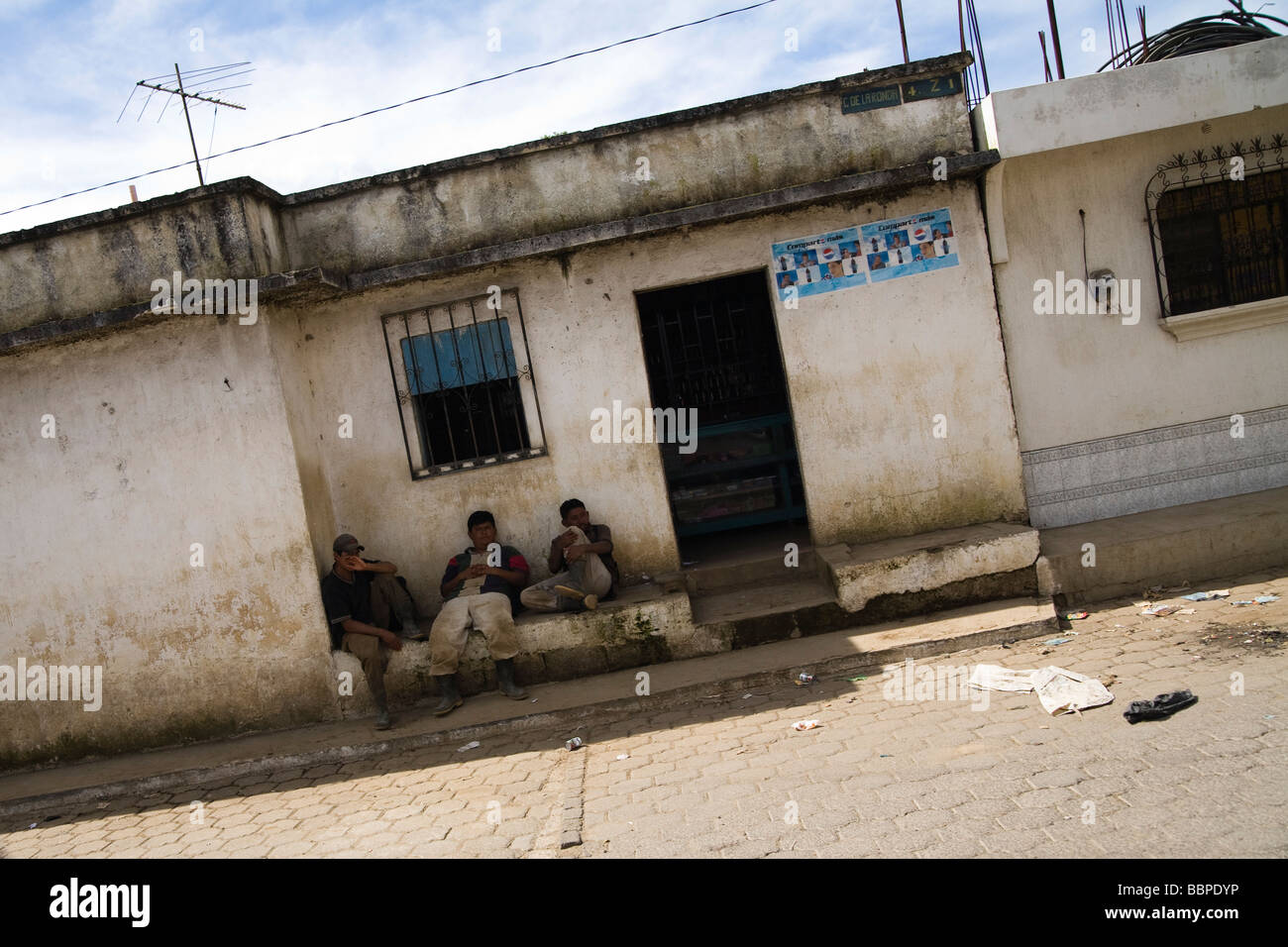 Central america three men sitting outside a run down building hi-res ...