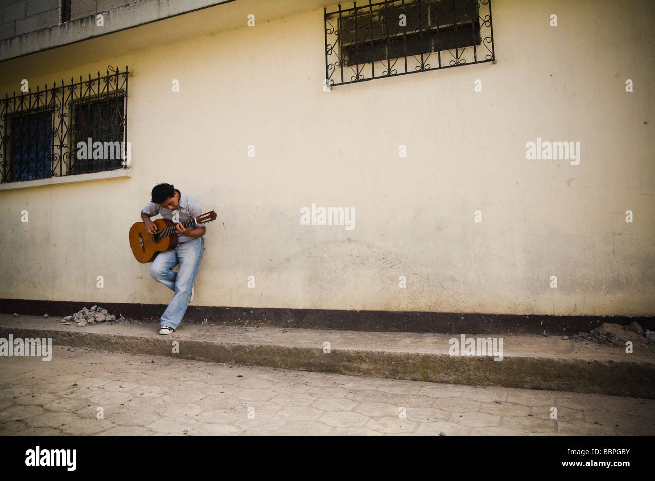 Patzicia,Guatemala;Man leaning against a wall playing guitar Stock ...