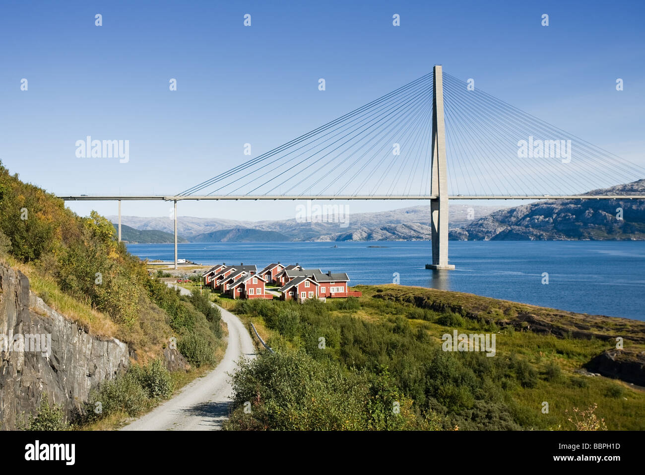 big modern bridge over the river between mountains with small village ...