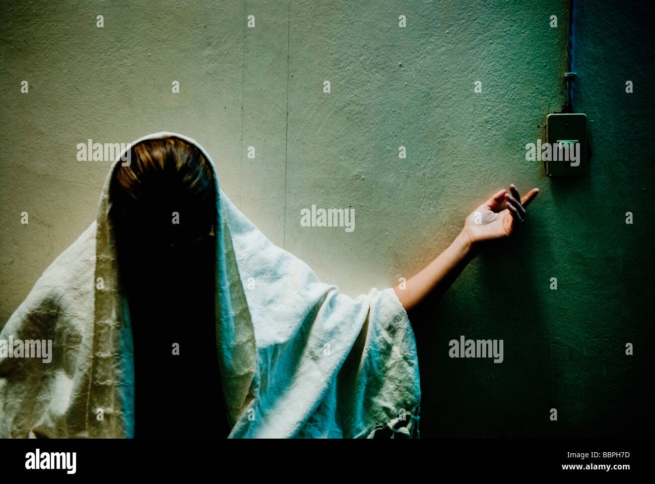 Mysterious shrouded figure reaching for light switch hi-res stock ...