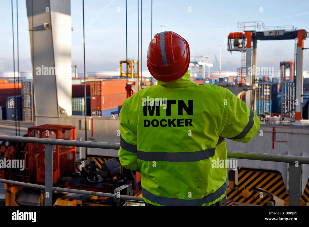 DOCKER AT THE LOADING OF CONTAINERS ONTO A CARGO BOAT, TERMINAL OF ...