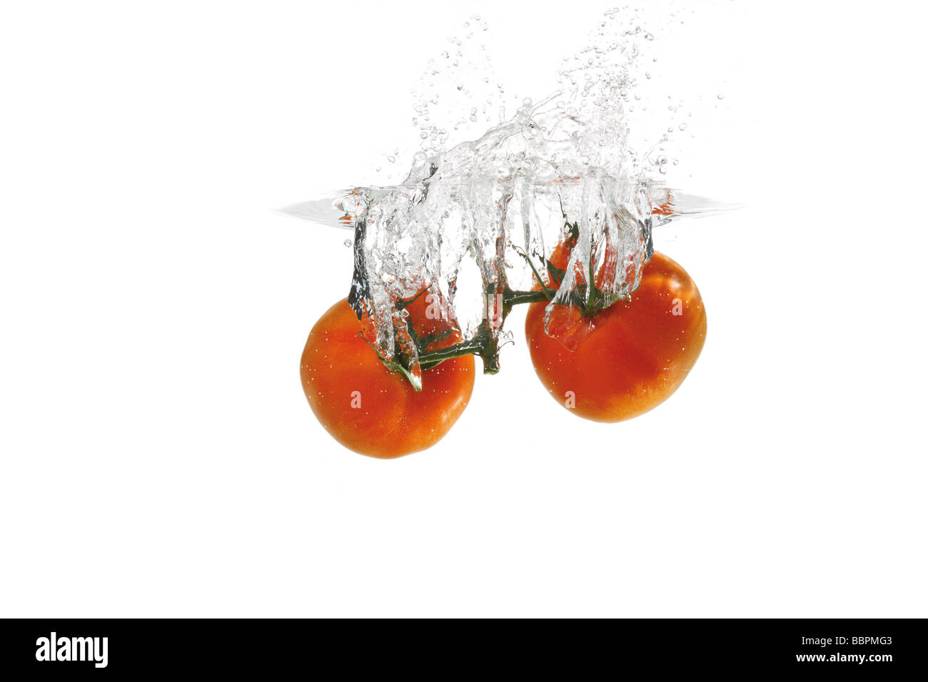 Tomatoes dropping into water Stock Photo - Alamy
