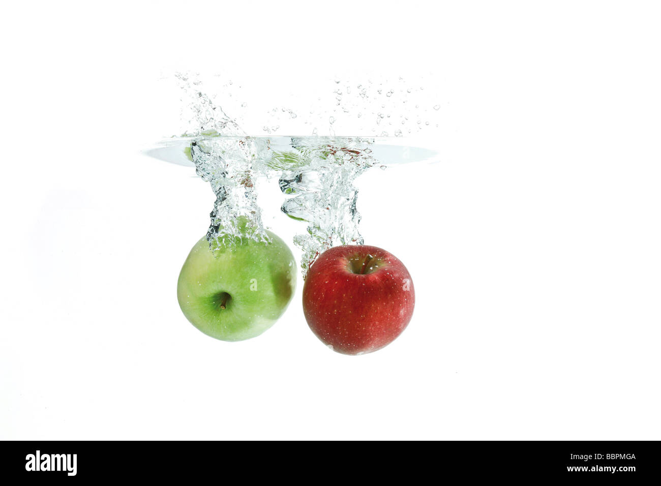 Red and green apple dropping into water Stock Photo - Alamy