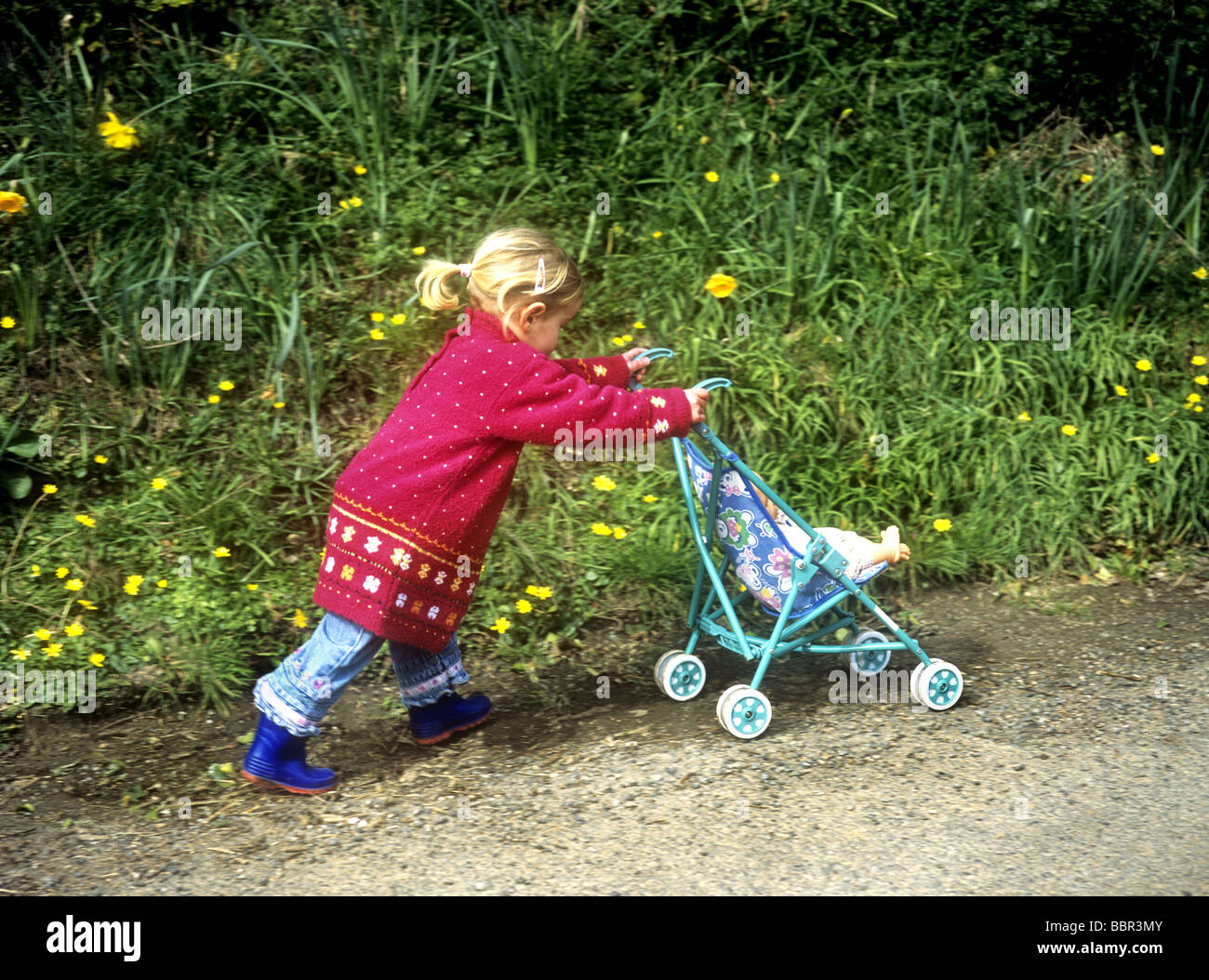 Toddler pushing a pram along country lane in spring Stock Photo - Alamy