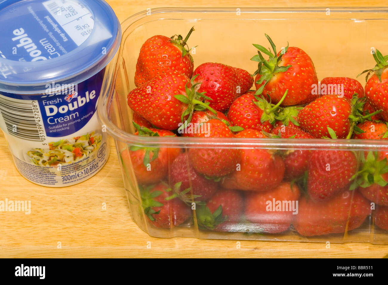 Punnet Of Strawberries With a Pot Of Fresh Double Cream Stock Photo - Alamy