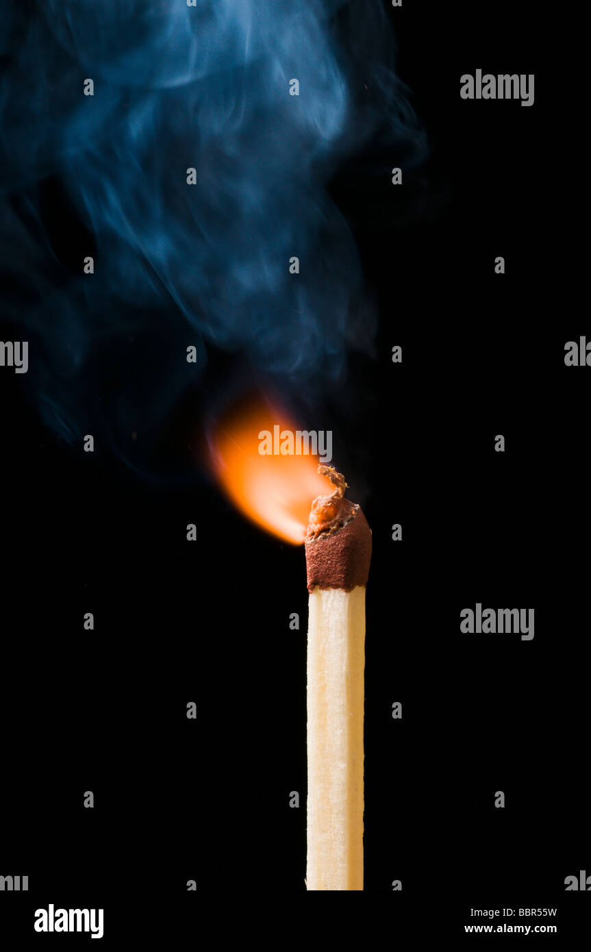 A close up of a match at the point of ignition on a black background ...