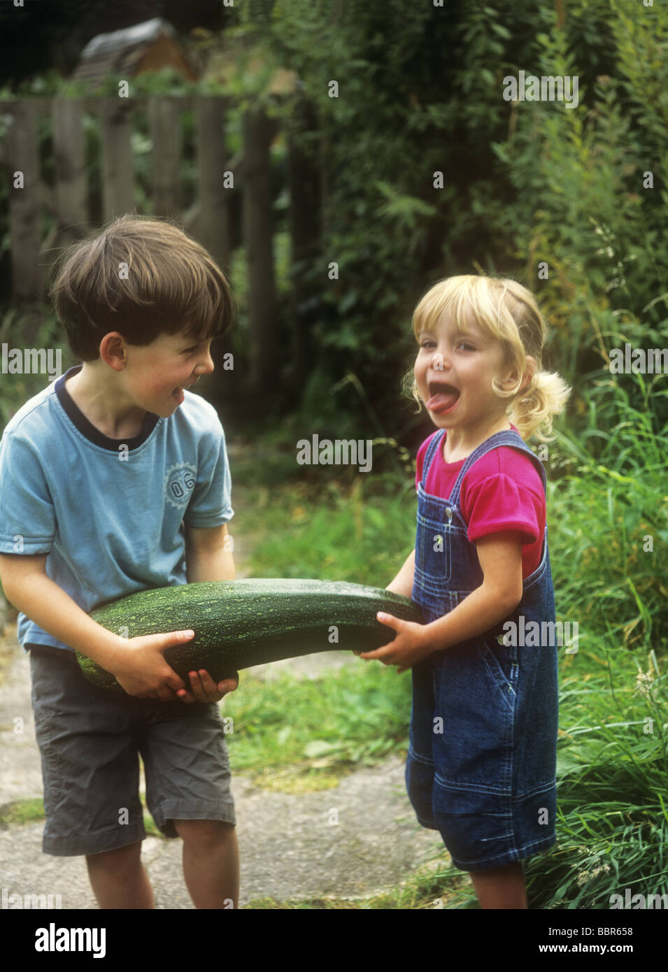 Cheeky young children holding marrow Stock Photo - Alamy