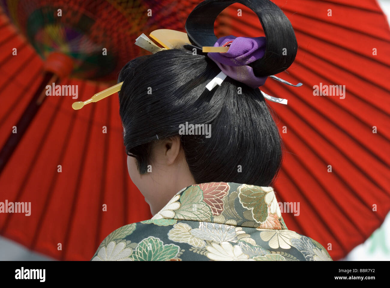 A woman dressed in festival costume and wearing a traditional wig ...