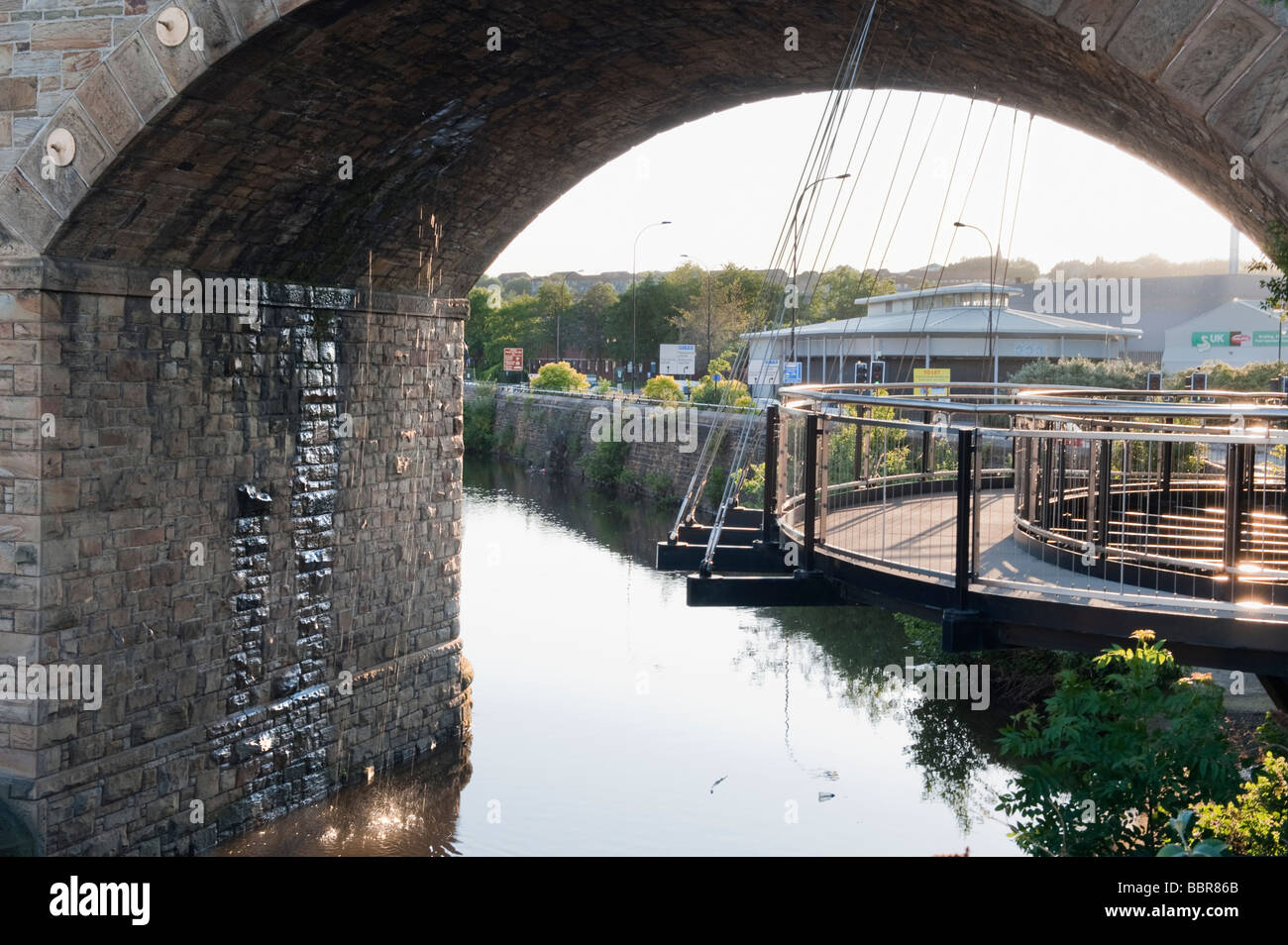Circular footbridge underneath a stone roadbridge supported by ...
