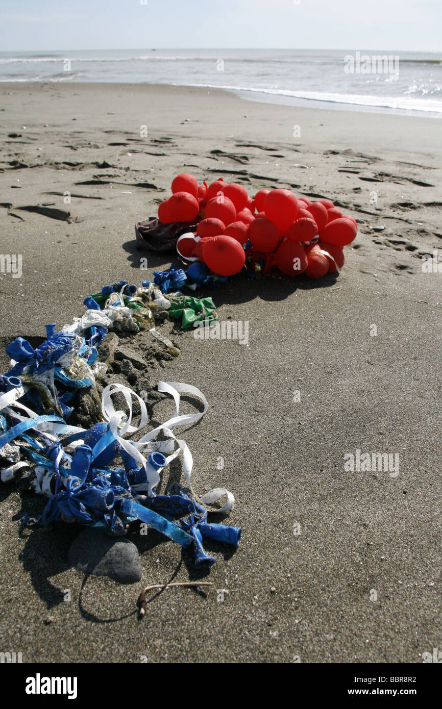 bunch of balloons washed up on coast by sea Stock Photo - Alamy
