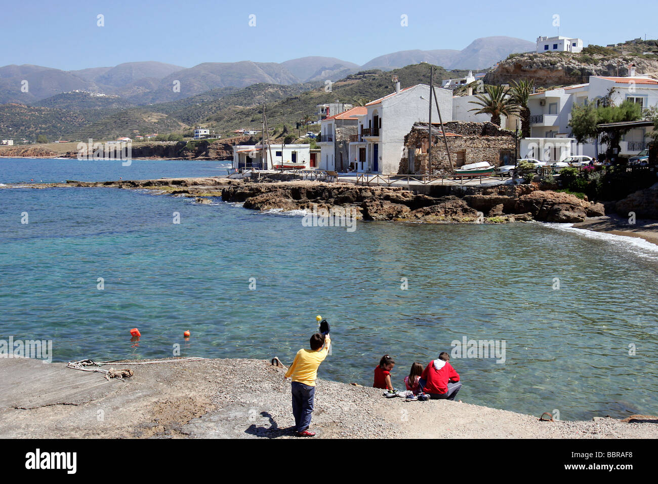 CHILDREN PLAYING ON THE EDGE OF THE QUAY, CRETE, GREECE Stock Photo - Alamy