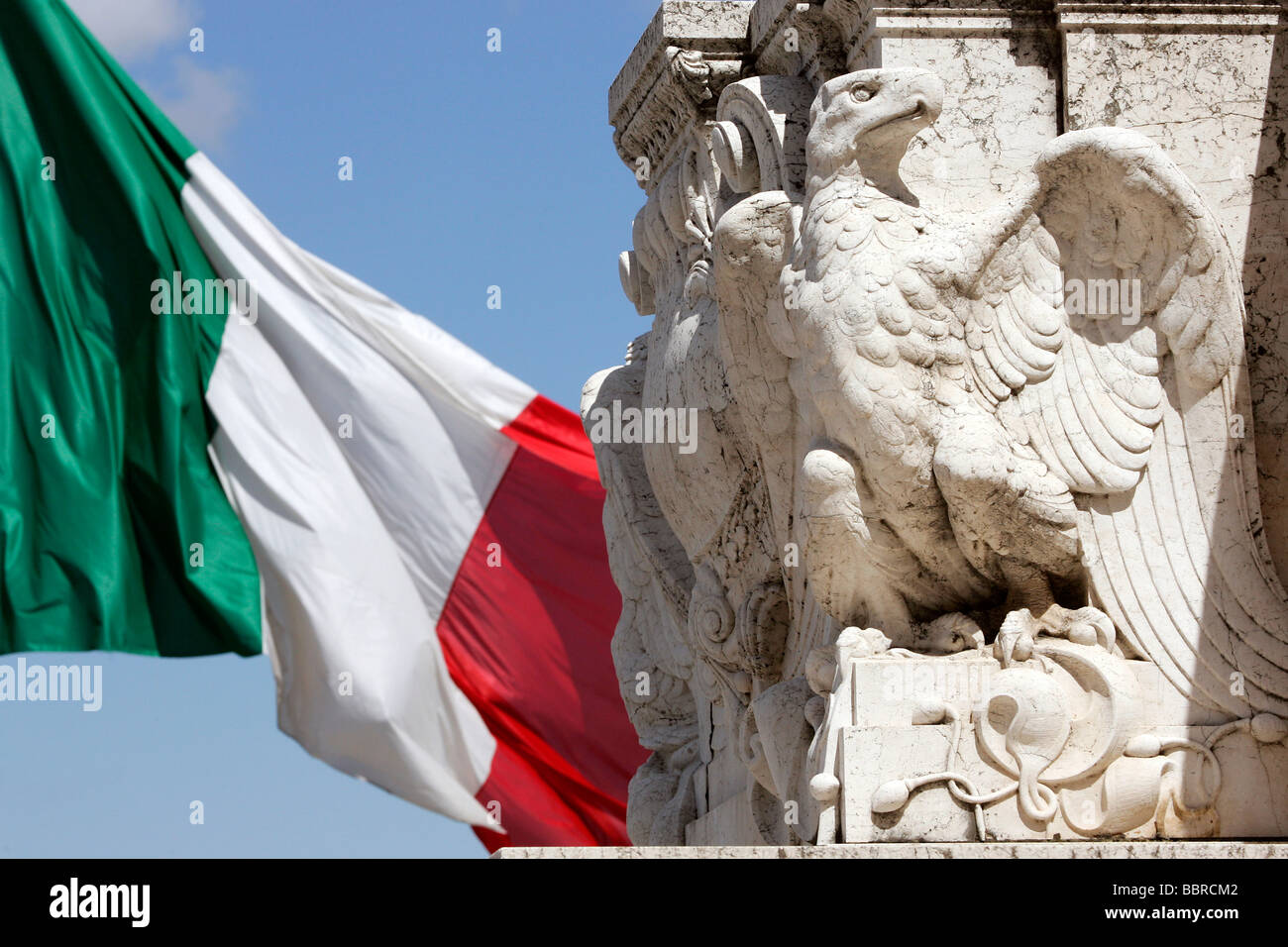 DETAIL OF A STATUE ON THE VICTOR EMMANUEL II PALACE AND ITALIAN FLAG ...