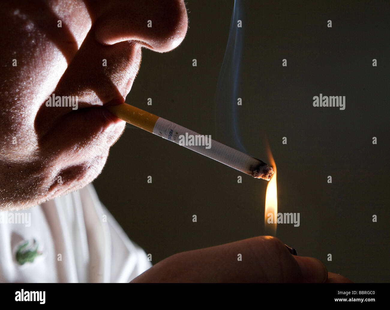 A smoker smokes a Rothmans cigarette made by British American Tobacco ...